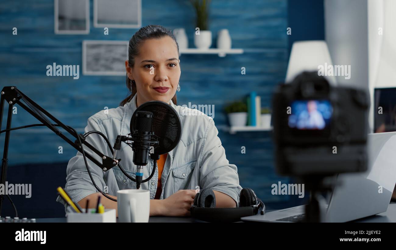 Popular social media influencer sitting at home studio desk while ...