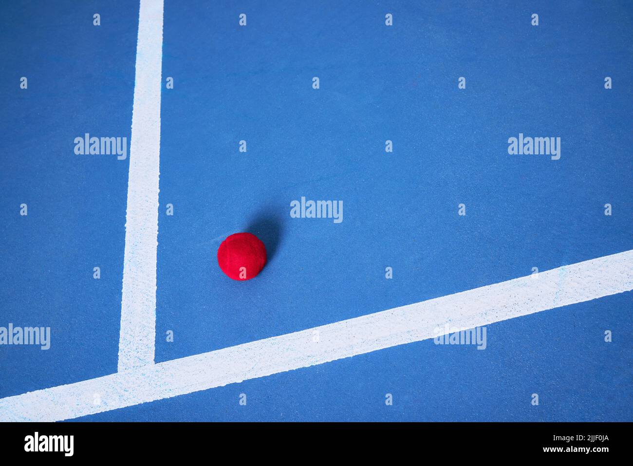 The ball is round, the game is long. one red tennis ball lying on a ...