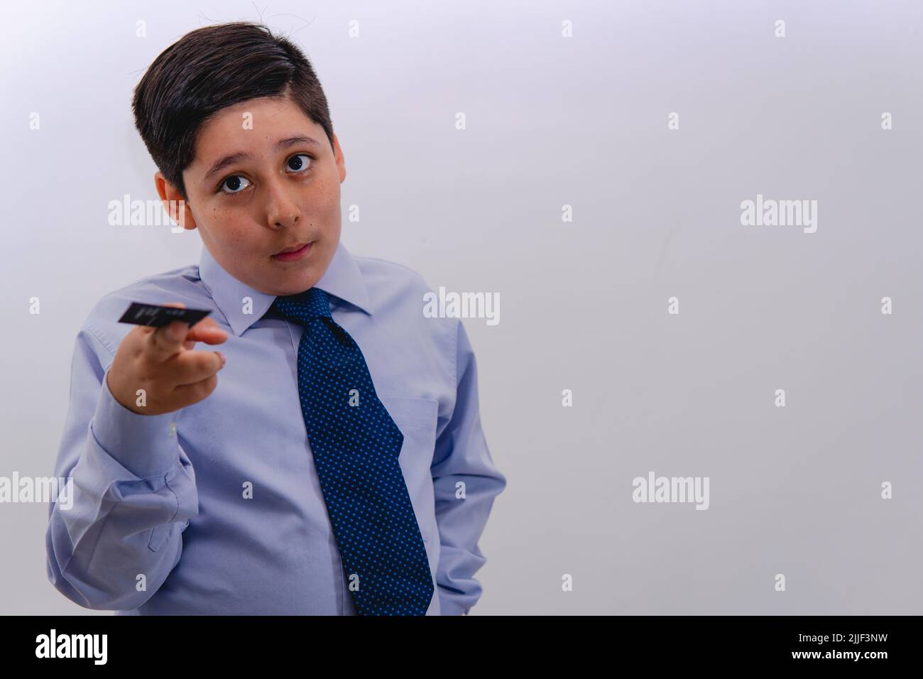 A little businessman boy dressed in a suit and tie handing his card to ...