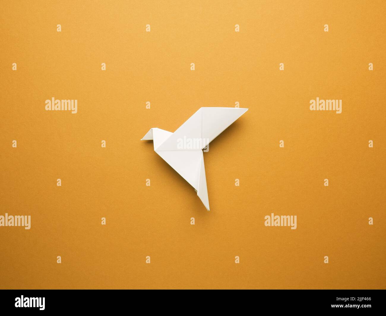 Origami peace dove on an orange paper background, freedom or peace ...