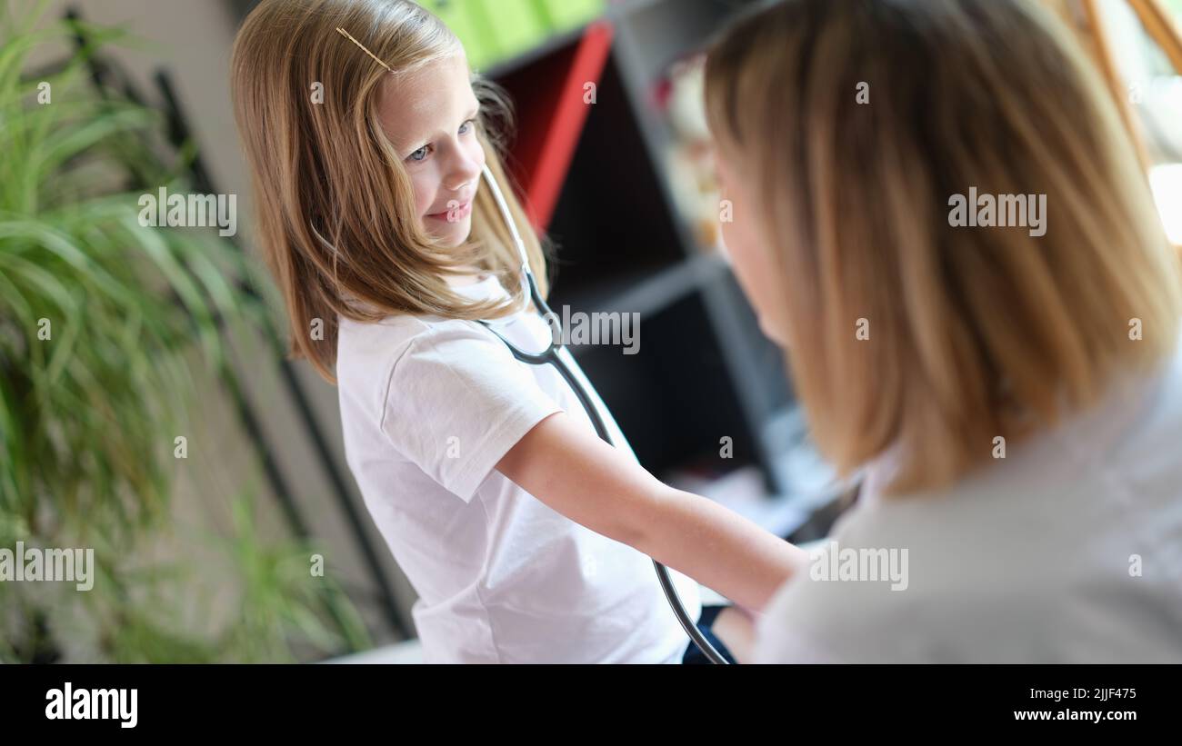 Happy little child using medical stethoscope at doctor appointment ...