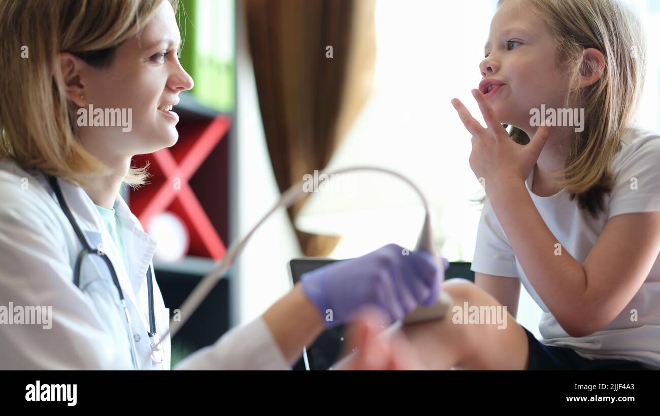 Doctor diagnosing injuries or defects of kid, little girl telling ...