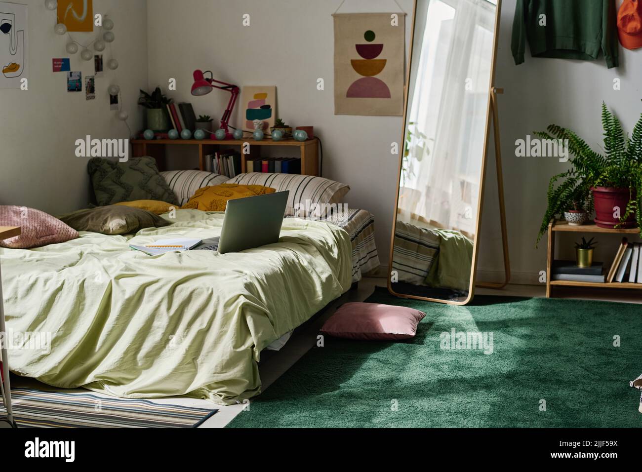 Horizontal image of modern teenage bedroom with bed and laptop on it ...