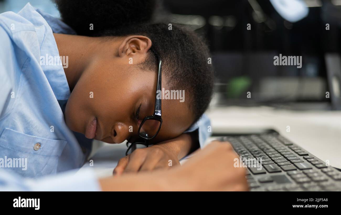 African young woman sleeping at work desk Stock Photo - Alamy