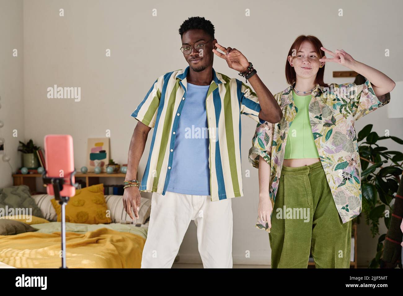 Couple of young vloggers dancing together on camera of smartphone ...