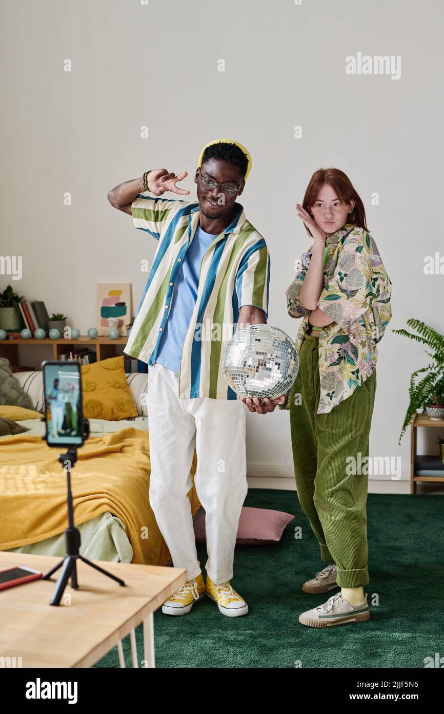 Couple of vloggers dancing with disco ball together and recording video ...