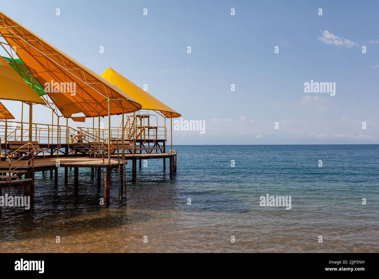 Swimming area or pier on the sea. A large pier with a roof, wooden ...