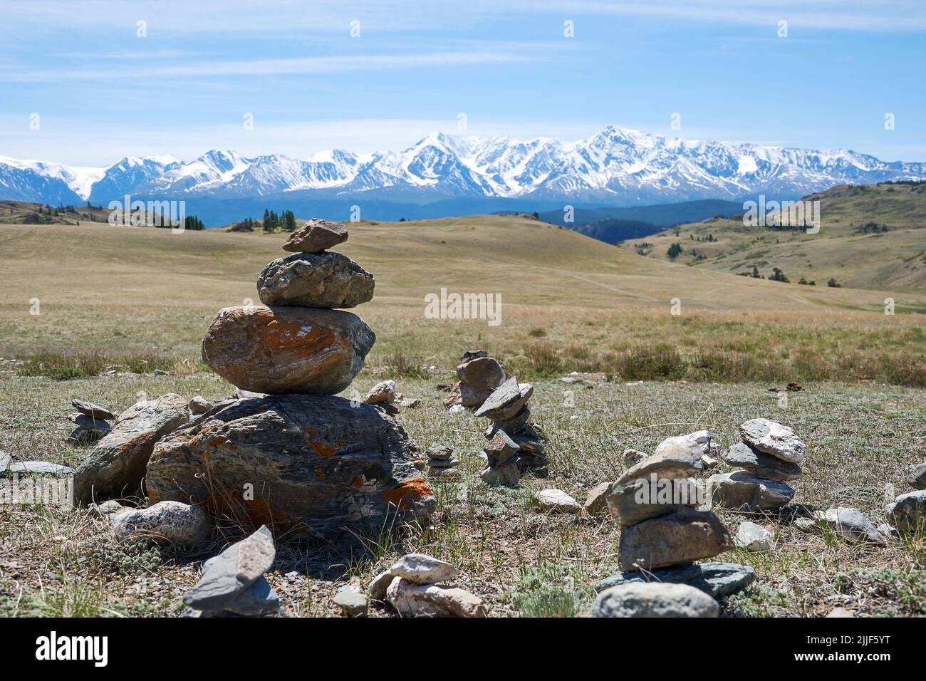 Balancing stone pyramid in the steppe against the backdrop of a snowy ...