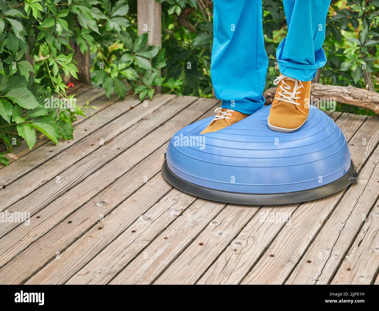 male feet and legs balancing on bosu half ball, backyard fitness ...