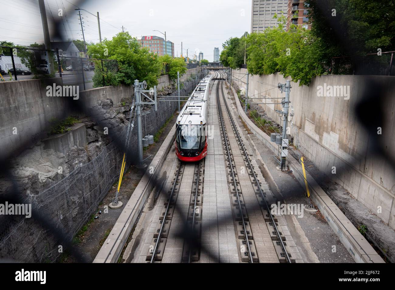 An Ottawa Light Rail Transit (LRT) train drives along the tracks in ...