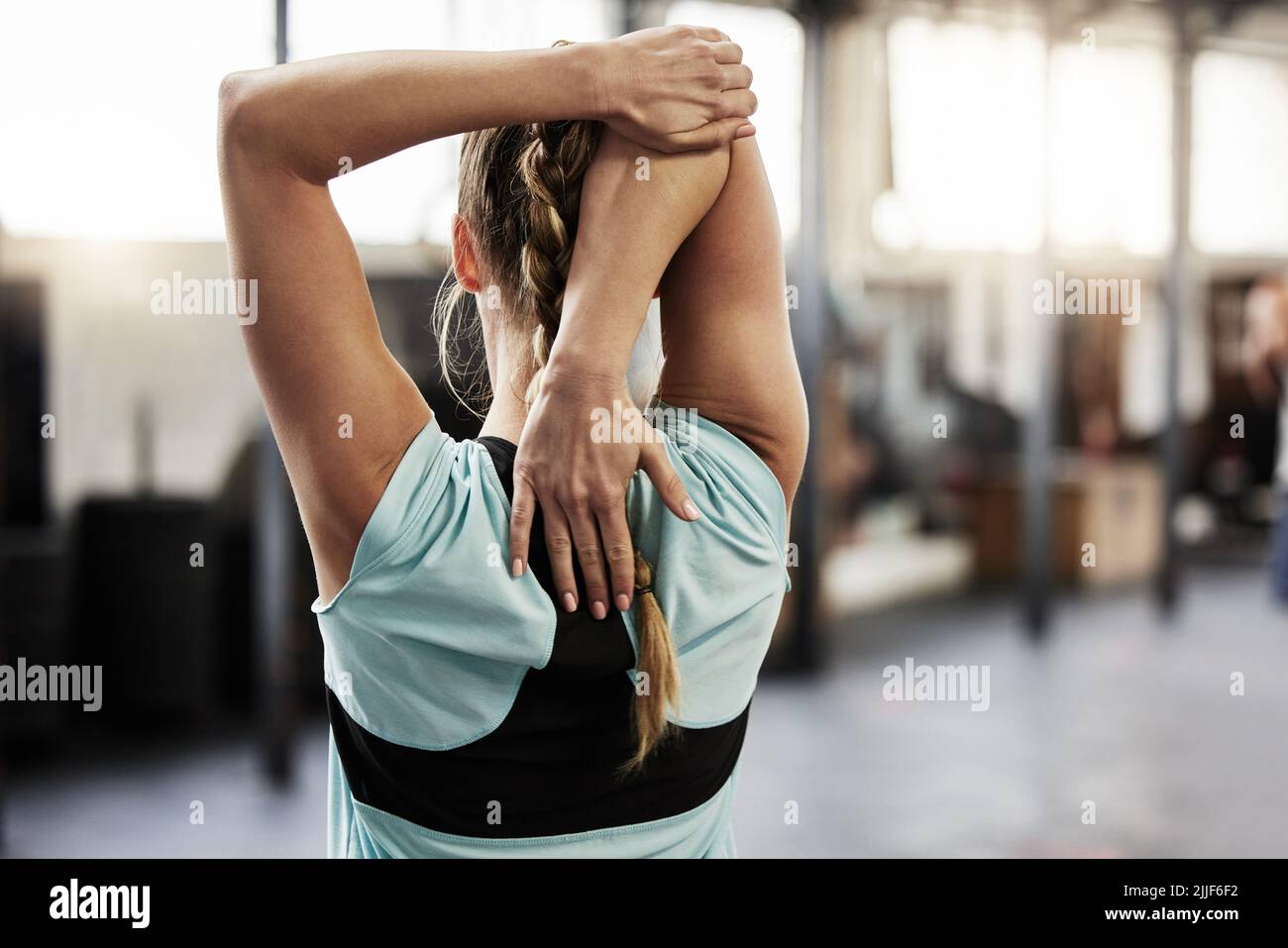 Dont forget to stretch. Rearview shot of a young woman stretching at ...