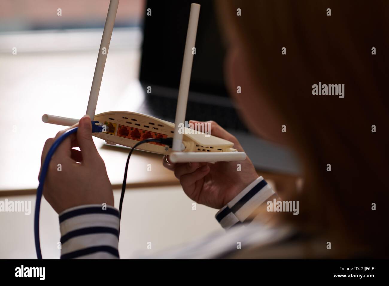 Woman plugging cord in wi-fi router to get internet access Stock Photo ...