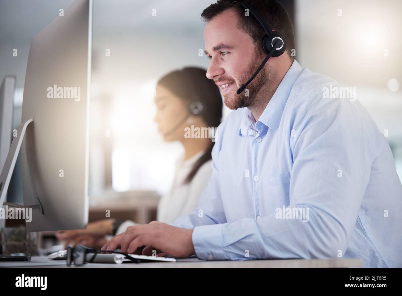 Give me a sec to log it for you. a young call centre agent working on a ...