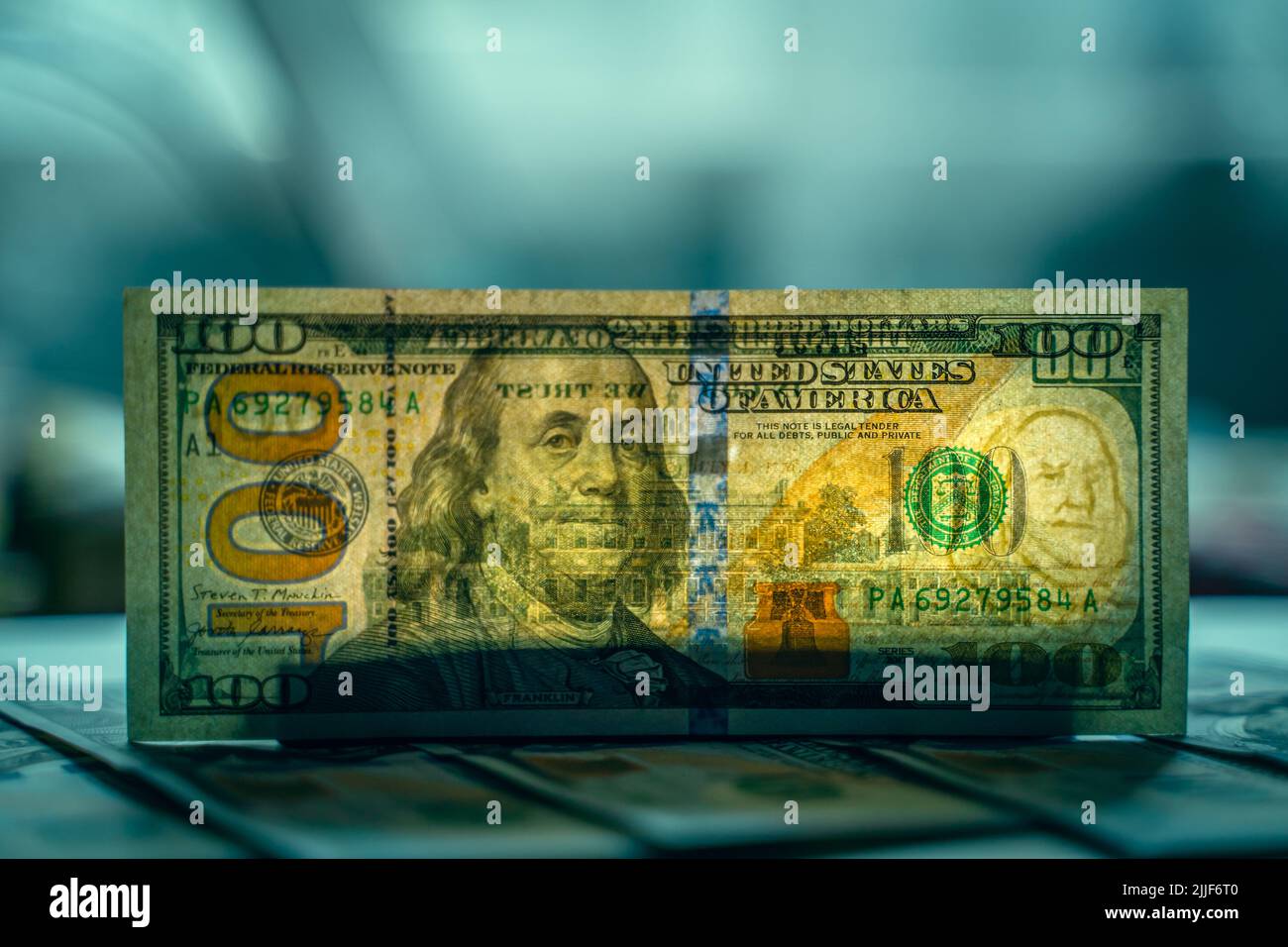 Hundred dollar bill close-up shines through a light source Stock Photo ...