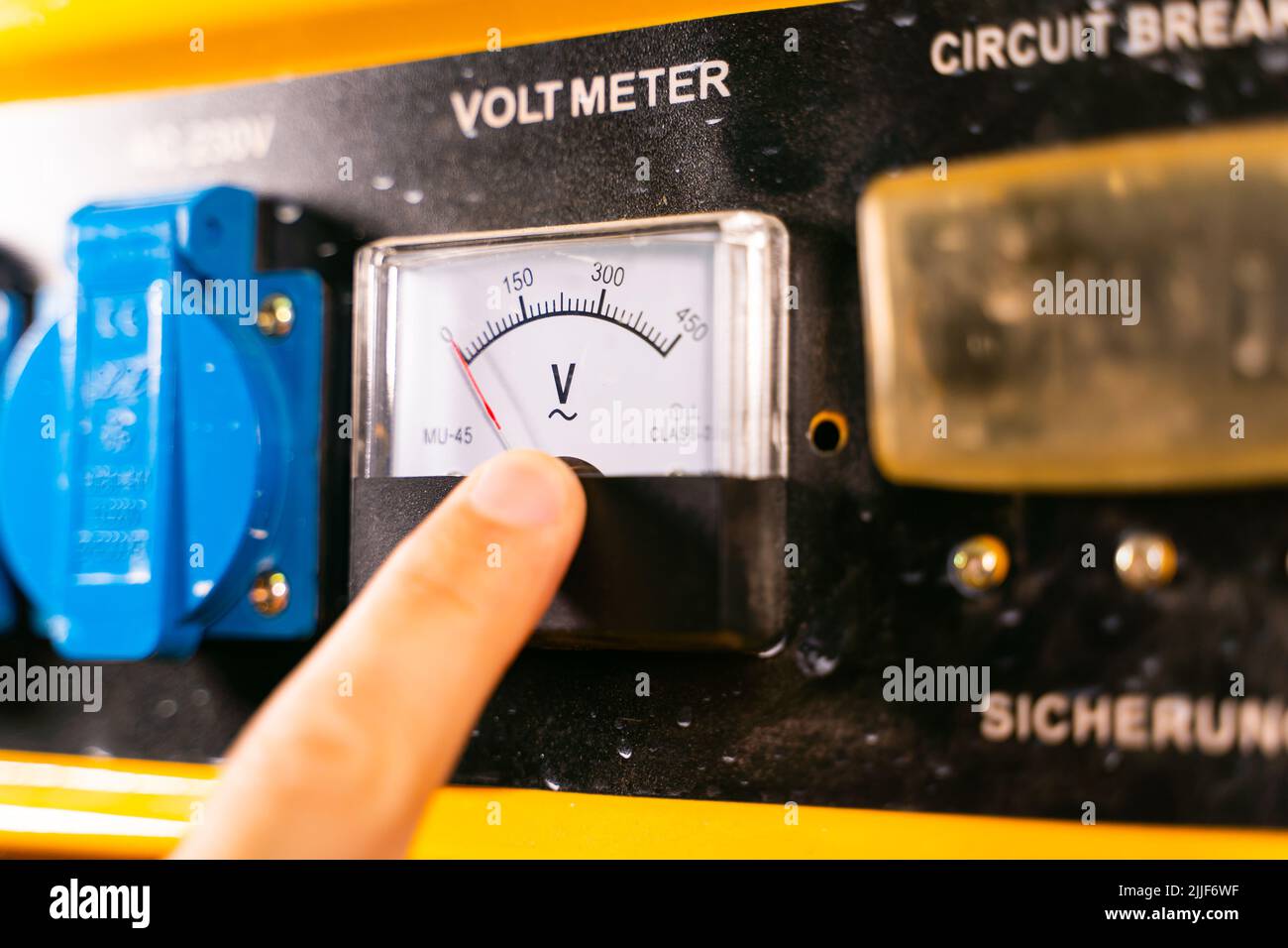 Voltmeter on the body of the gas generator close-up. Finger points to ...