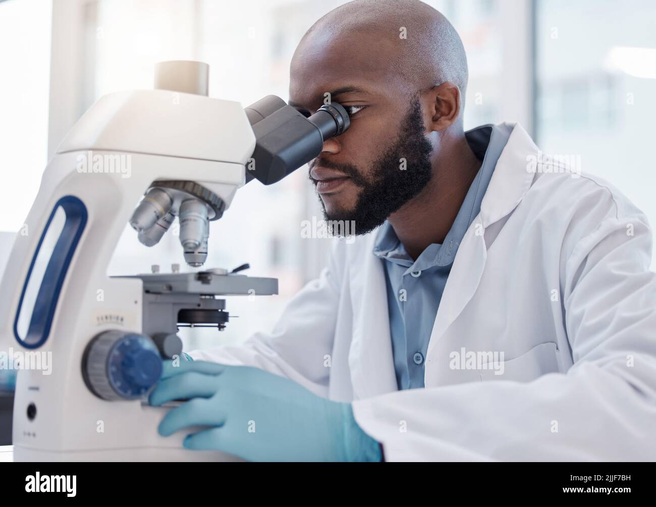 Success is a science. a young scientist using a microscope in a ...