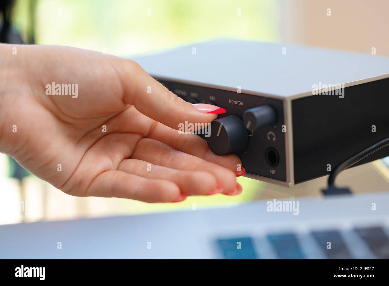 Unrecognizable young woman hands adjusting audio mixer setting sound in ...