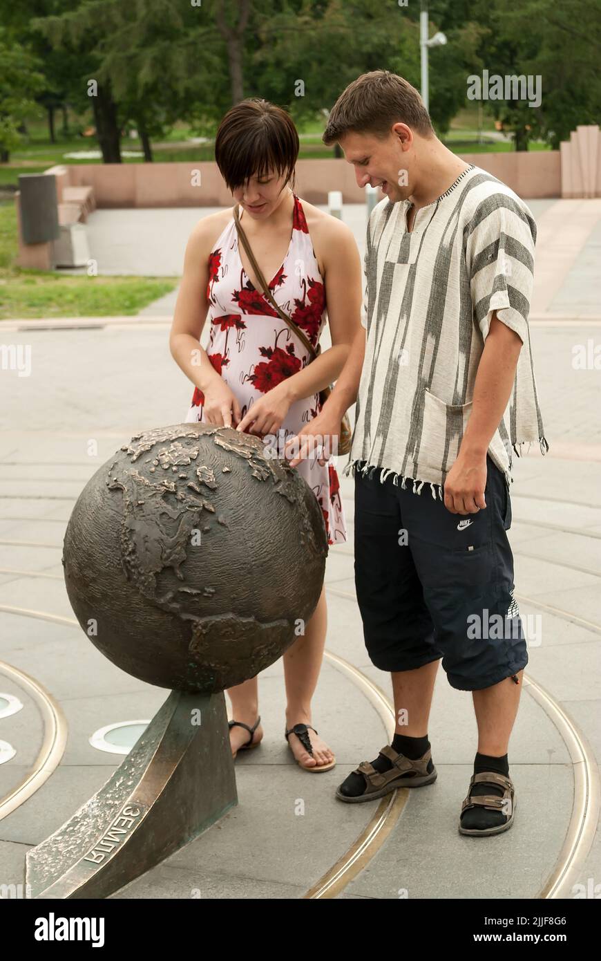 Young people look on Earth model Stock Photo - Alamy