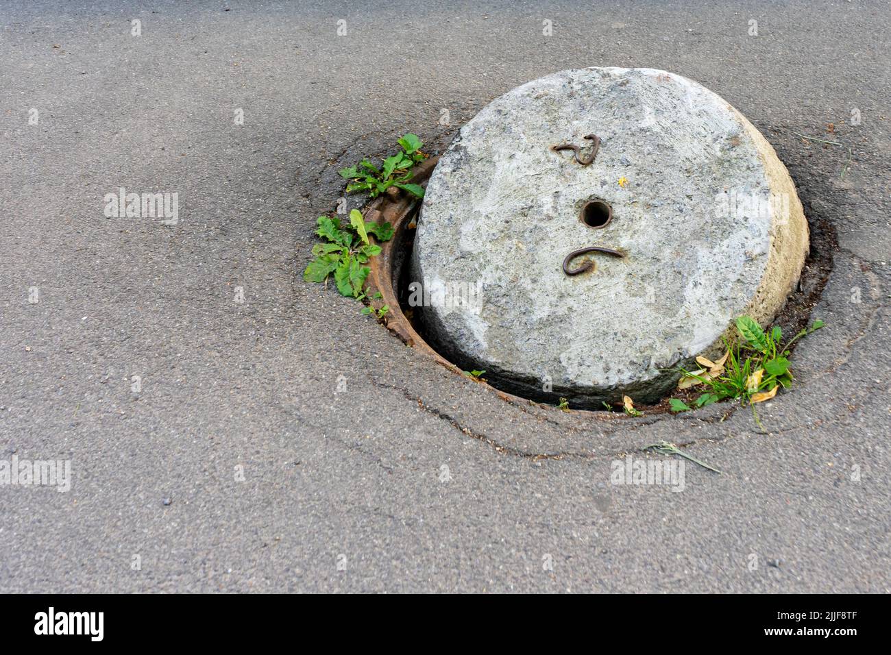 An old sewer manhole with an open concrete cover Stock Photo - Alamy