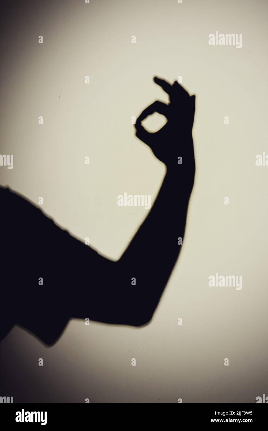 Shadow of a hand from the night light of a flashlight on a white wall ...