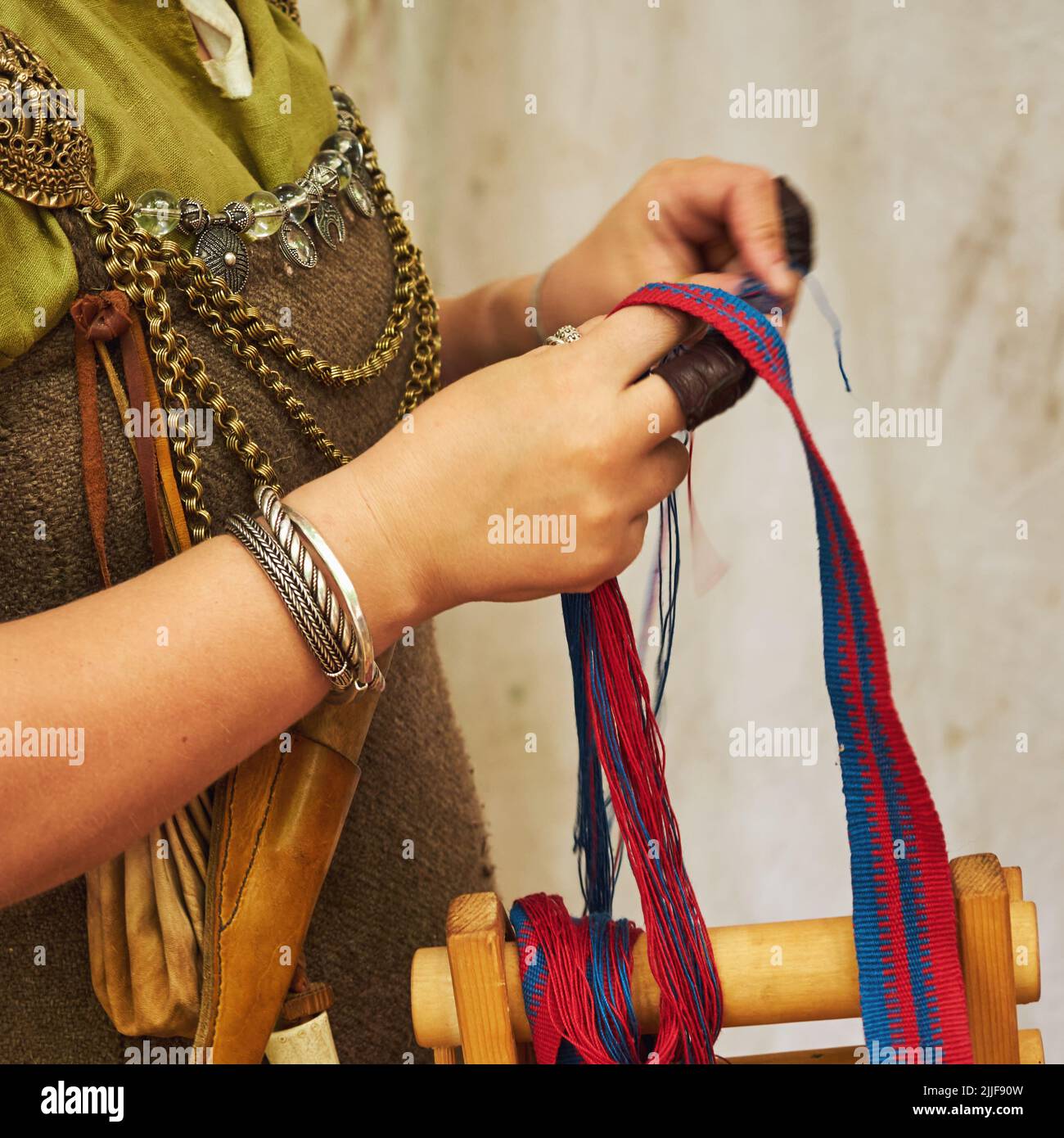 A woman in ancient Byzantine clothing makes yarn and sews from vintage ...