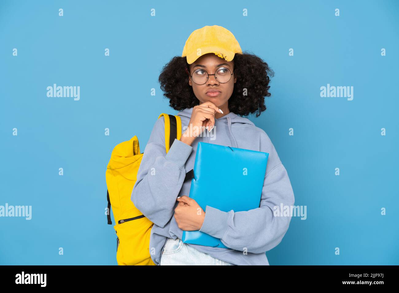 Black puzzlement woman posing with backpack and folder isolated over ...