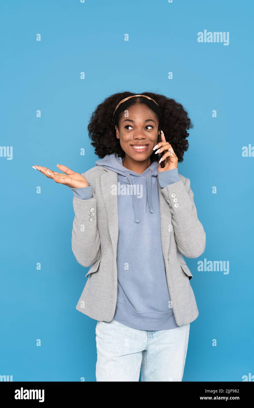 Young black woman talking on cellphone while holding copyspace isolated ...
