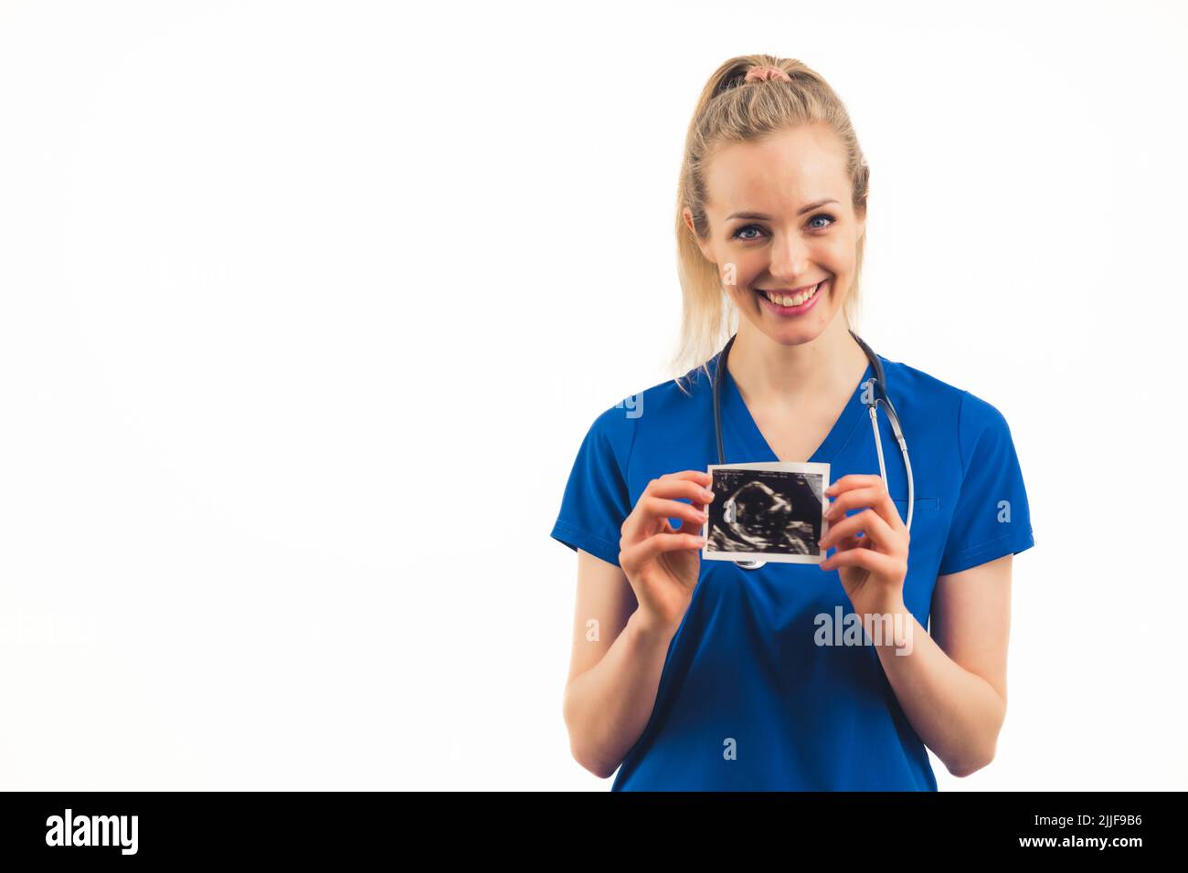 A smiling caucasian nurse showing a photo of an embryo - closeup. High ...
