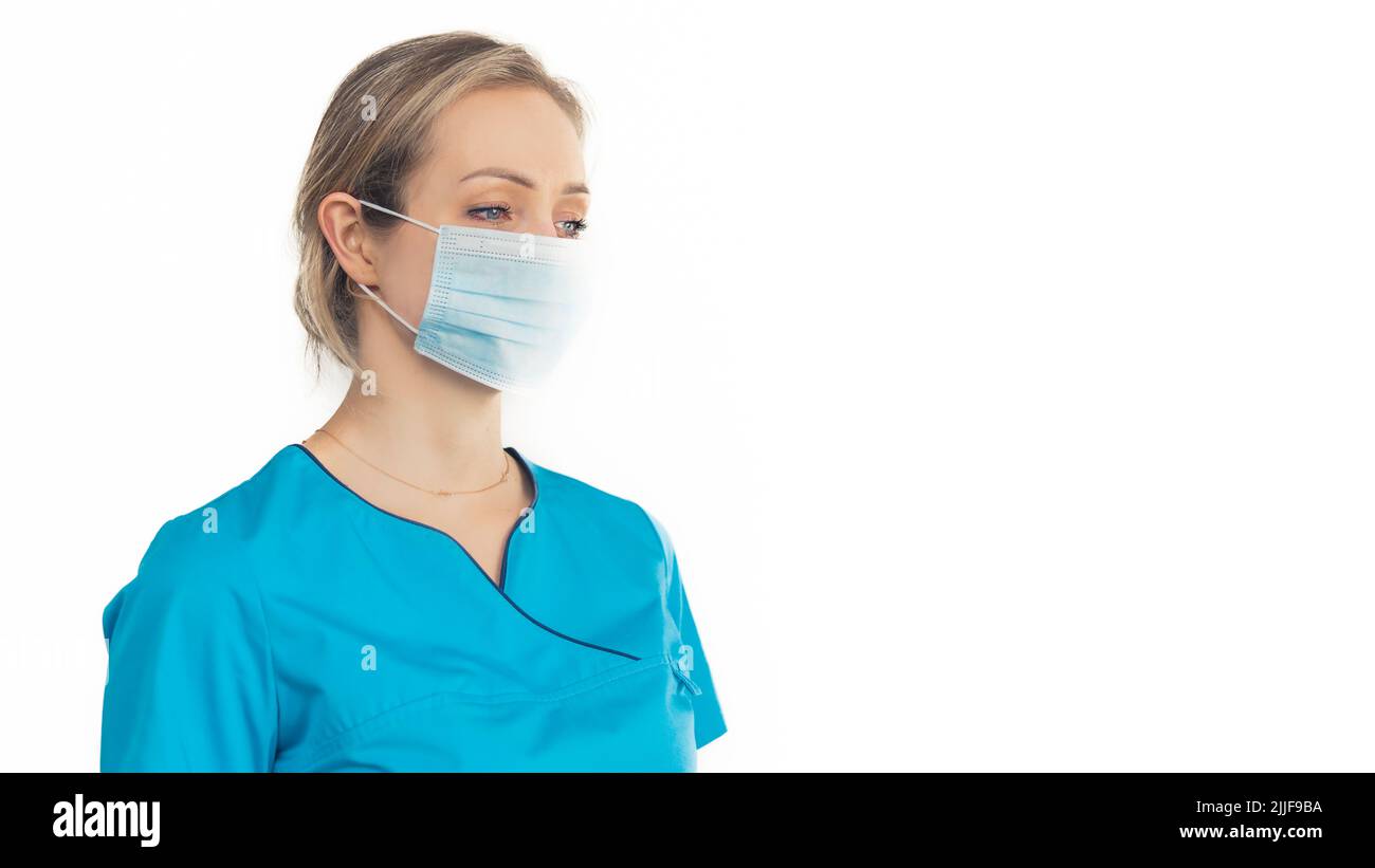 Beautiful nurse with blond hair and blue eyes wearing a protective face ...