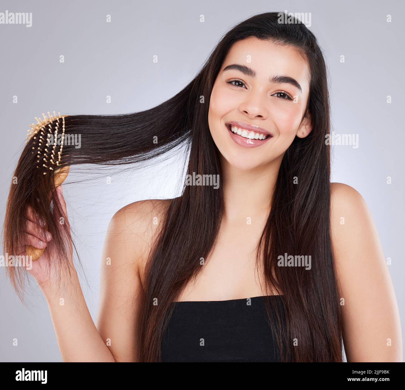 Smooth your hair while keeping it nourished. Studio portrait of an ...