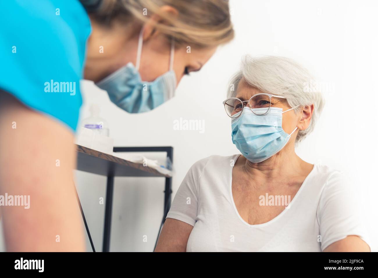 Senior lady with grey hair and her glasses on smiling sincerely at the ...
