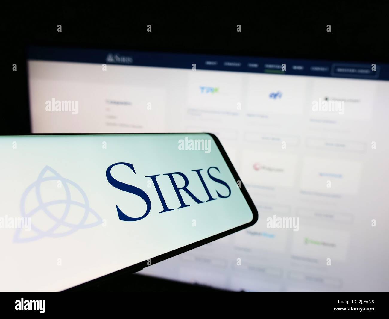 Mobile phone with logo of US investment company Siris Capital Group LLC on screen in front of ...