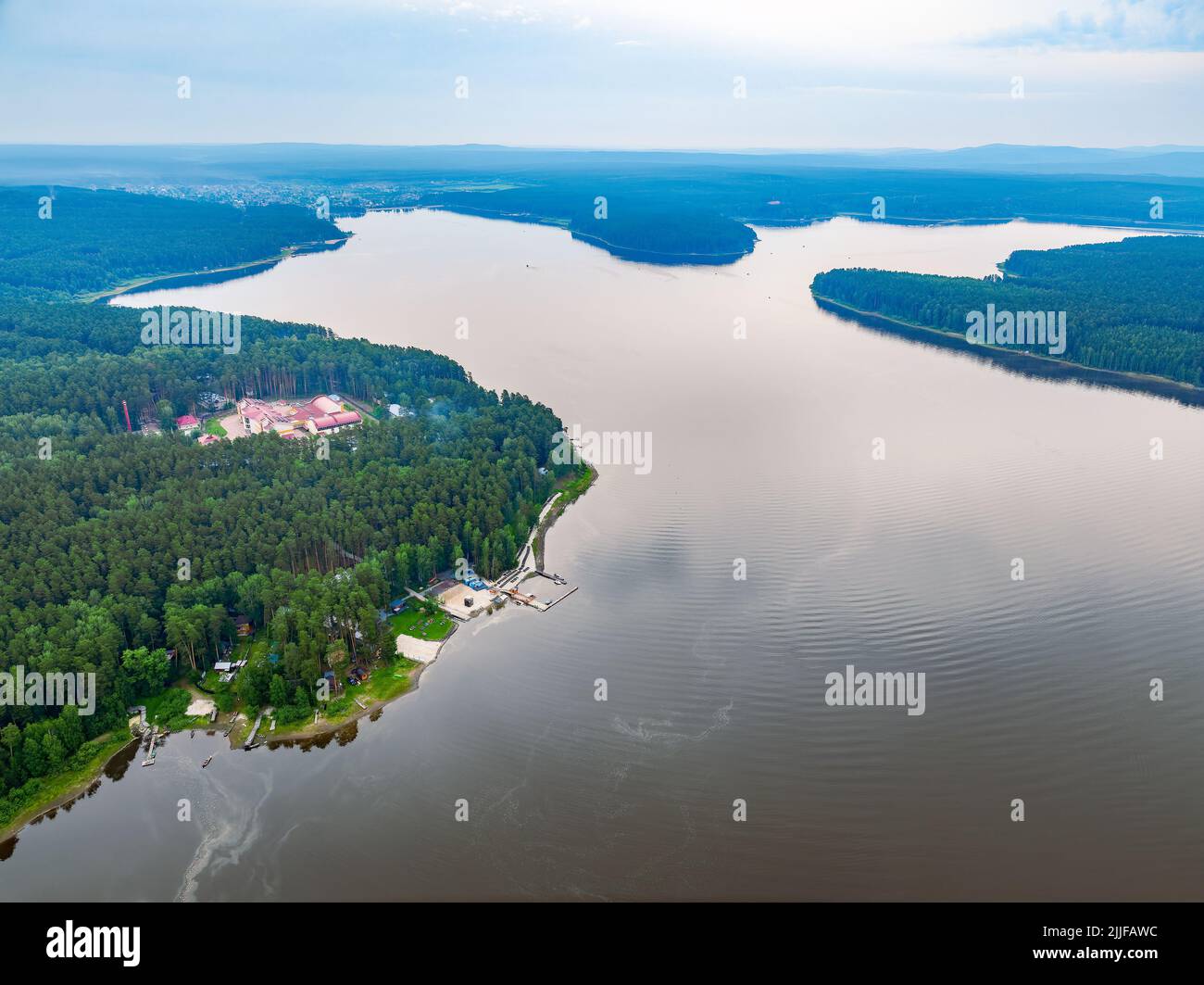 Big lake with green shores in bright sun light, aerial landscape ...