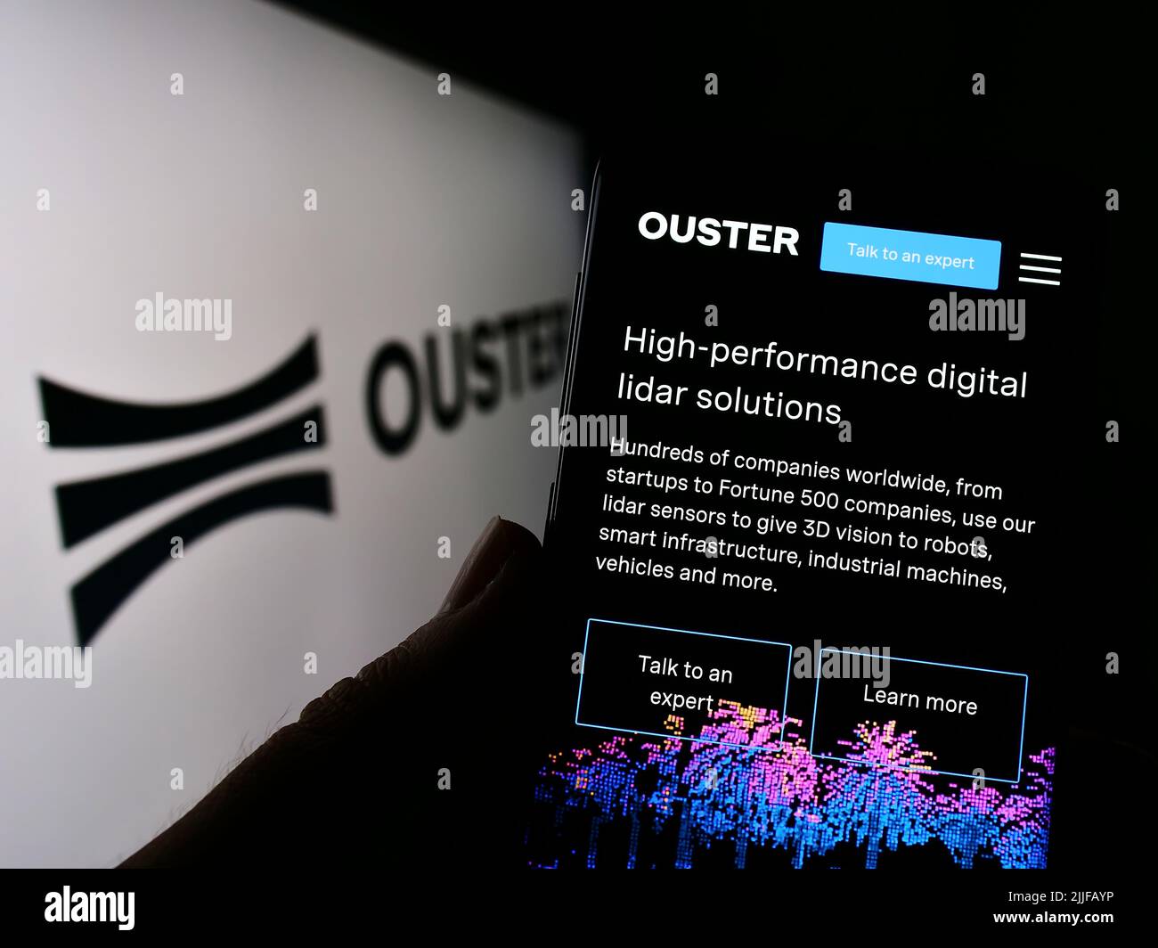 Person holding cellphone with webpage of US lidar technology company ...