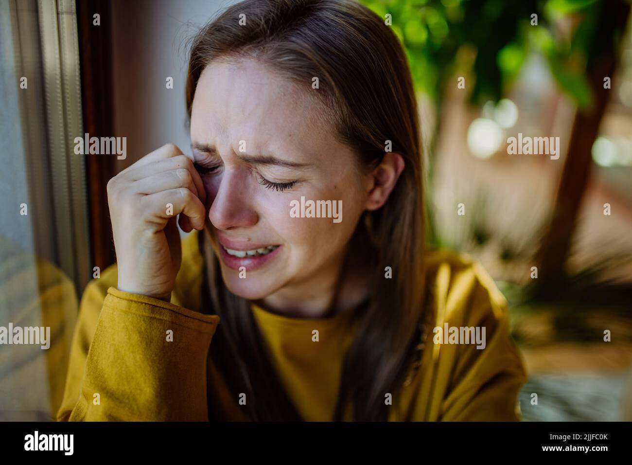 Woman suffering from depression and crying at home Stock Photo - Alamy