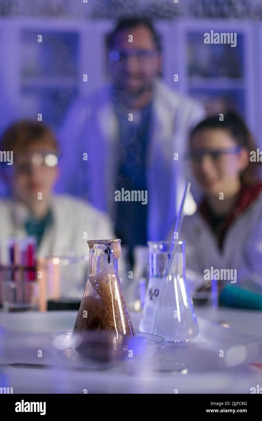 Science students with teacher doing chemical reaction experiment in the ...