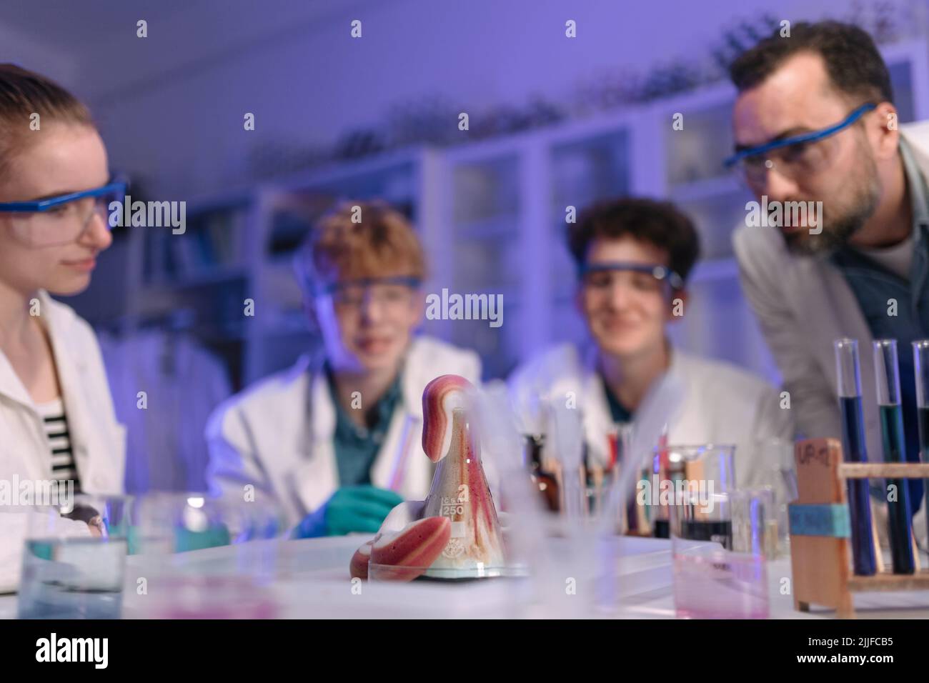 Science students with teacher doing chemical reaction experiment in the ...