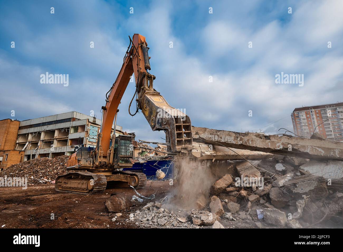 Excavator with hydraulic press breaks concrete leftovers Stock Photo - Alamy