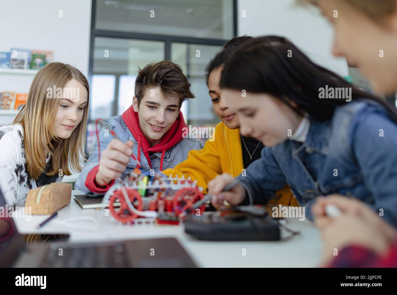 Group of high school students building and programming electric toys ...