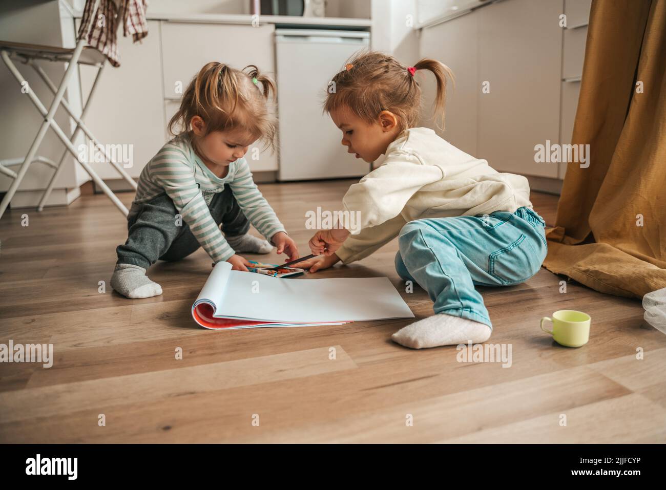 Cute female children playing in the kitchen Stock Photo - Alamy