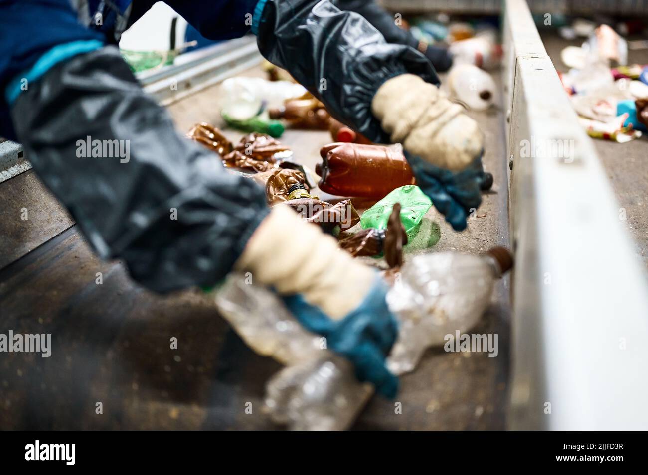 Worker sorts trash on conveyor belt at waste recycling plant Stock Photo - Alamy