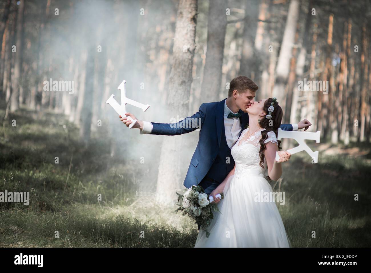 A young happy Caucasian married couple kissing each other and posing in ...
