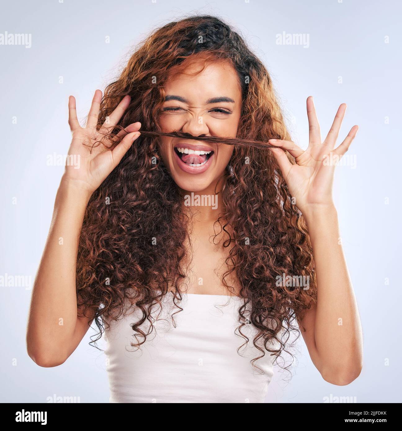 Moustache. an attractive young woman making a moustache with her hair ...