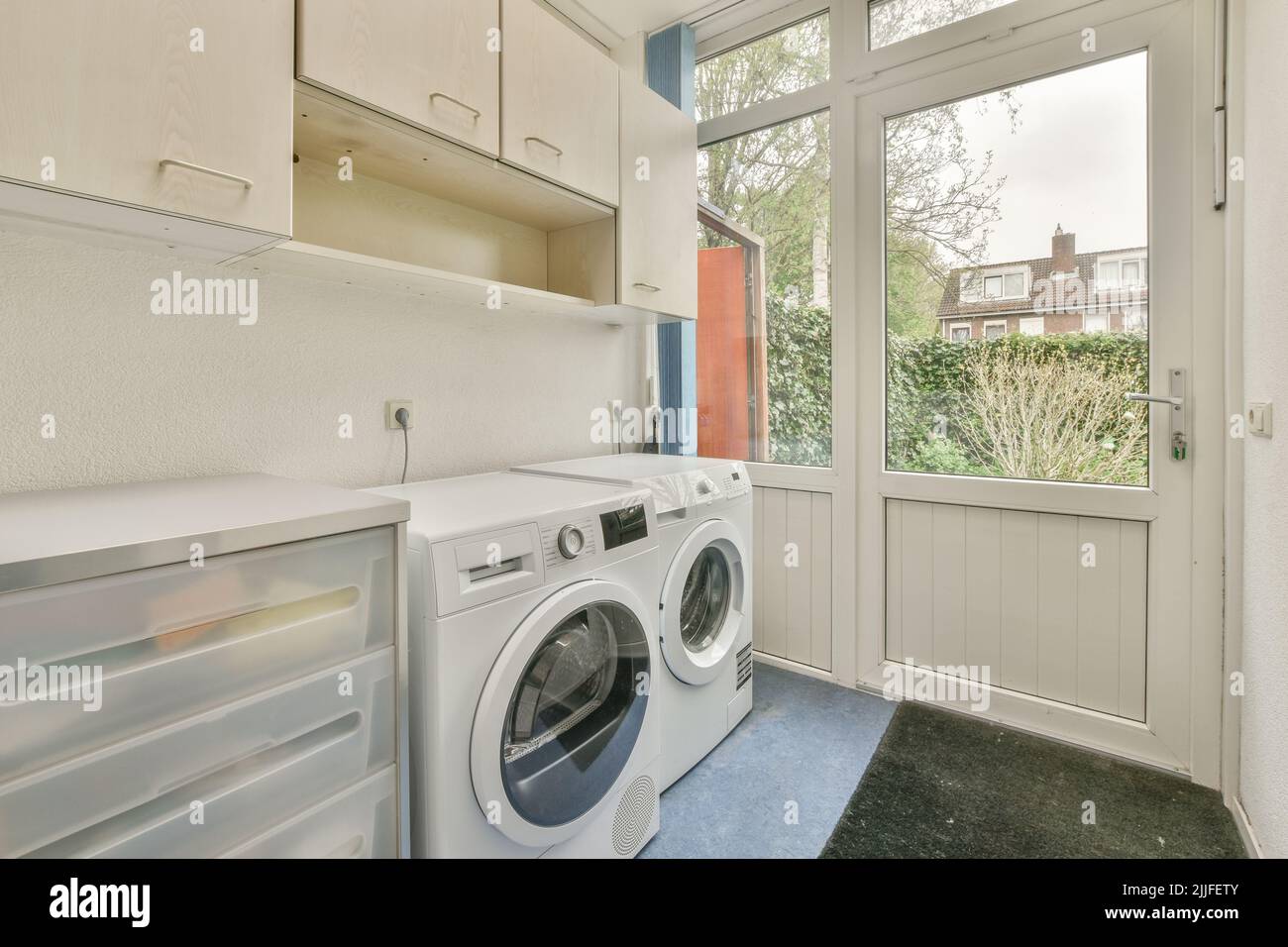 Interior of modern bright laundry room with white walls and dark ...