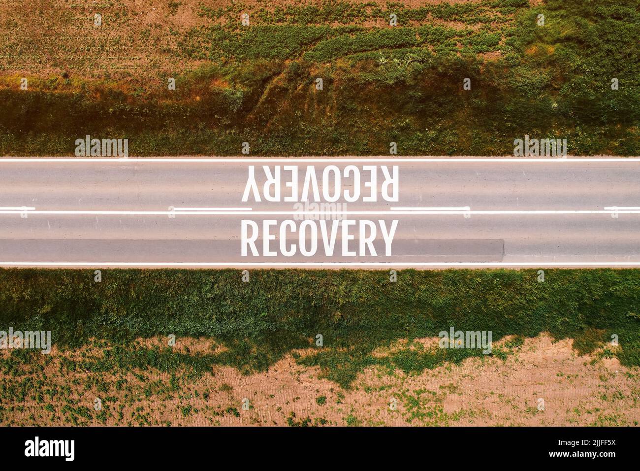 Recovery road concept, text on asphalt road from drone pov, directly ...