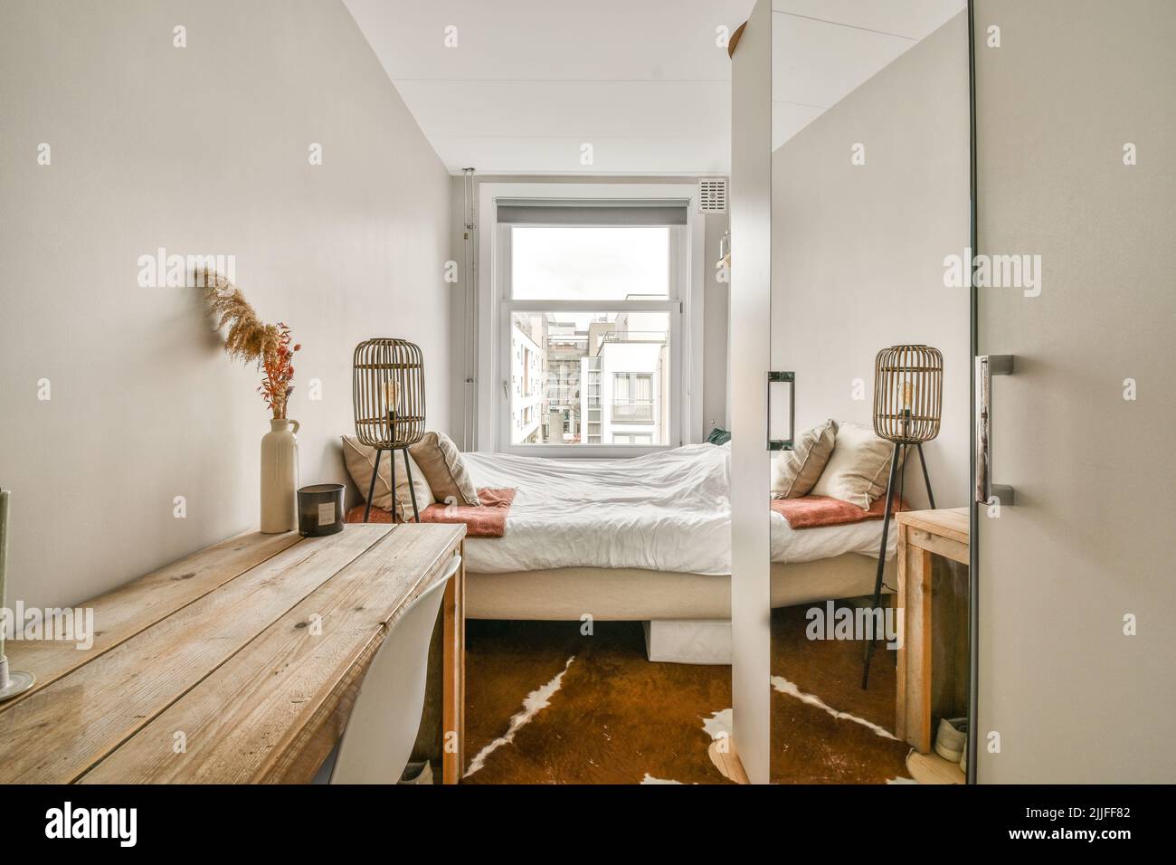 Stylish lamp glowing on vintage bedside table near wide bed under ...