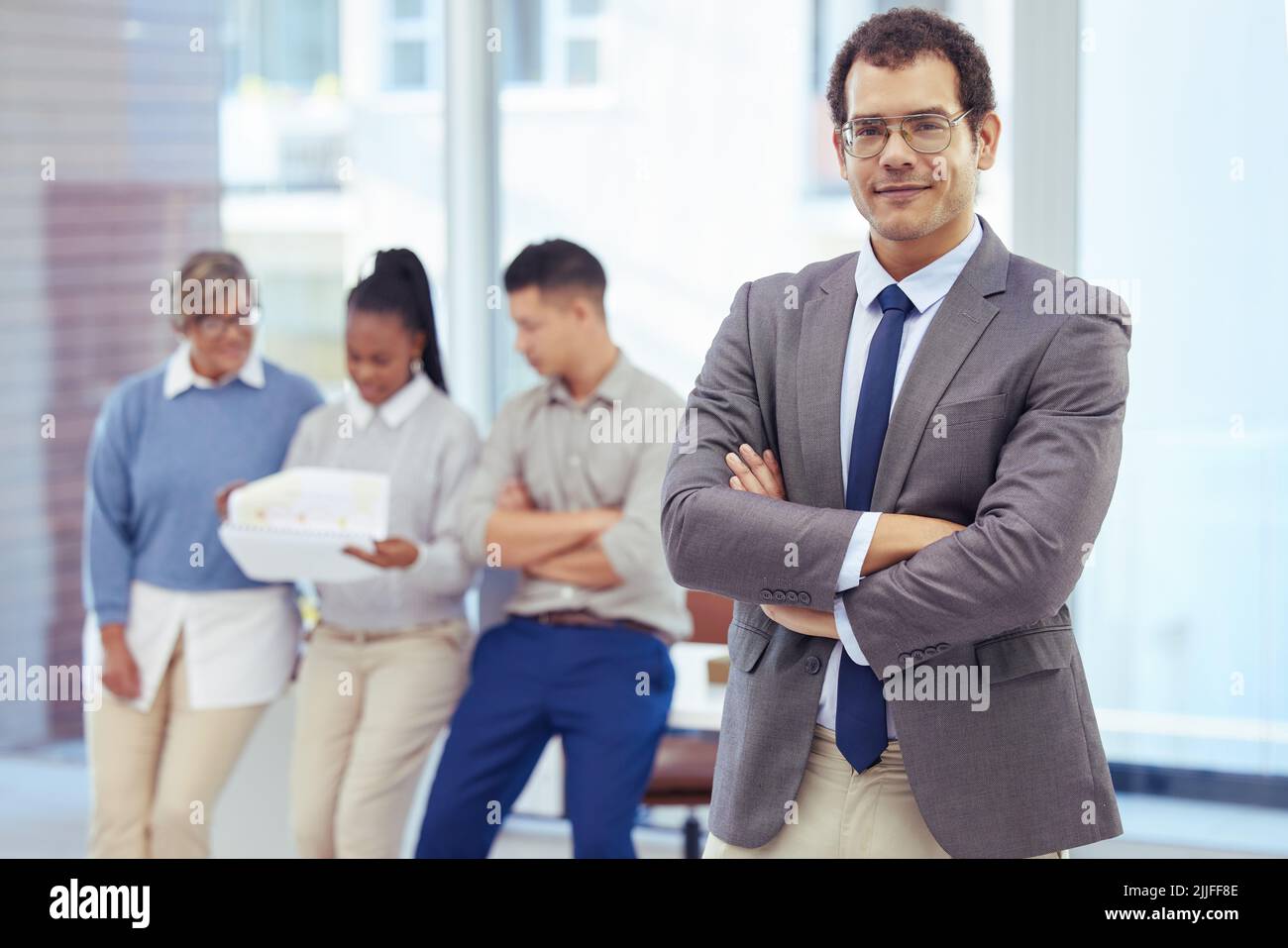 Leading his team through his plan. a businessman standing with her arms ...