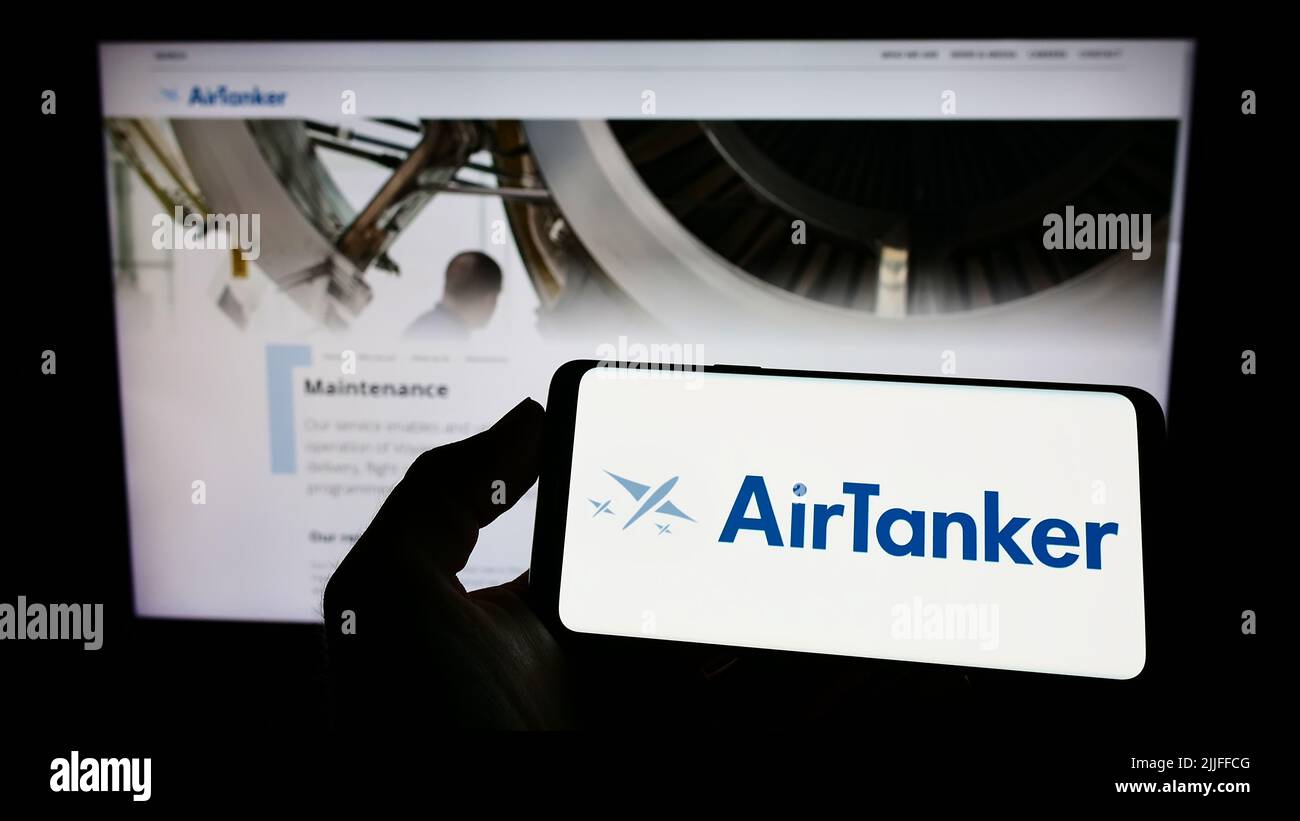 Person holding mobile phone with logo of British company AirTanker ...