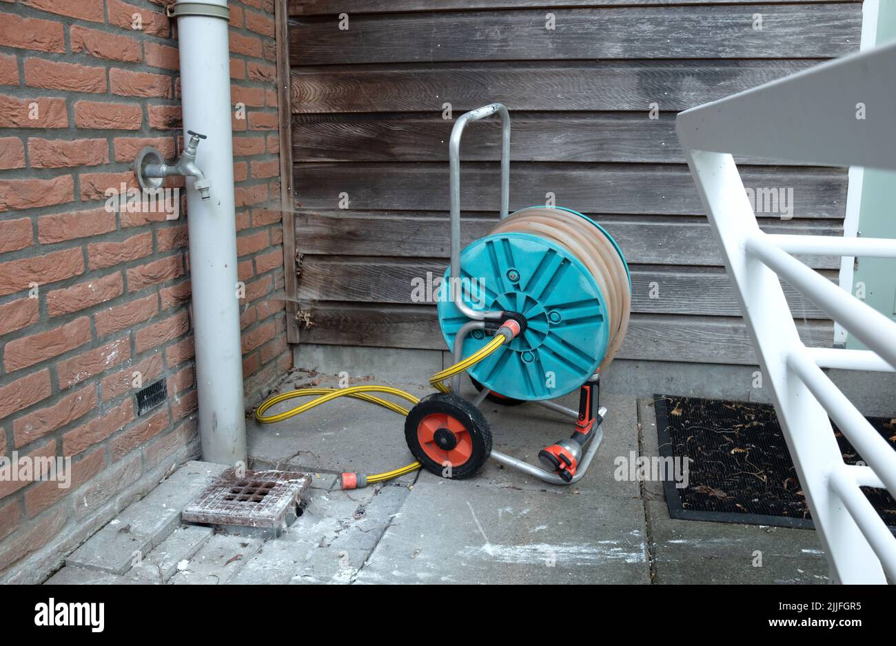 Watering garden hose on a blue spool Stock Photo - Alamy