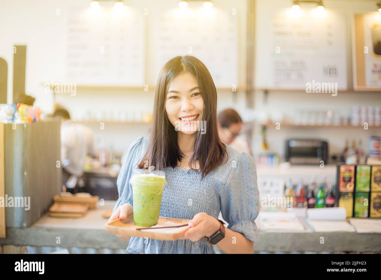 Happy smiling asian women drinking with ice matcha green tea indoor ...